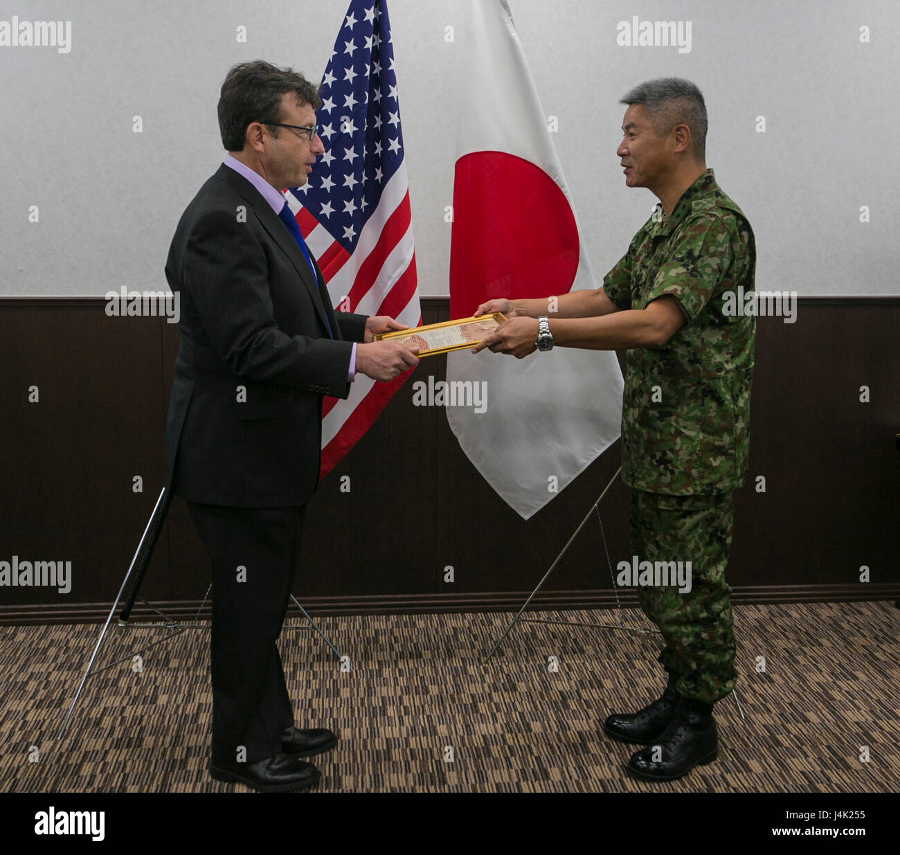 Maj. Gen. Tomofusa Harada, right, presents Mr. John Peters with the ...
