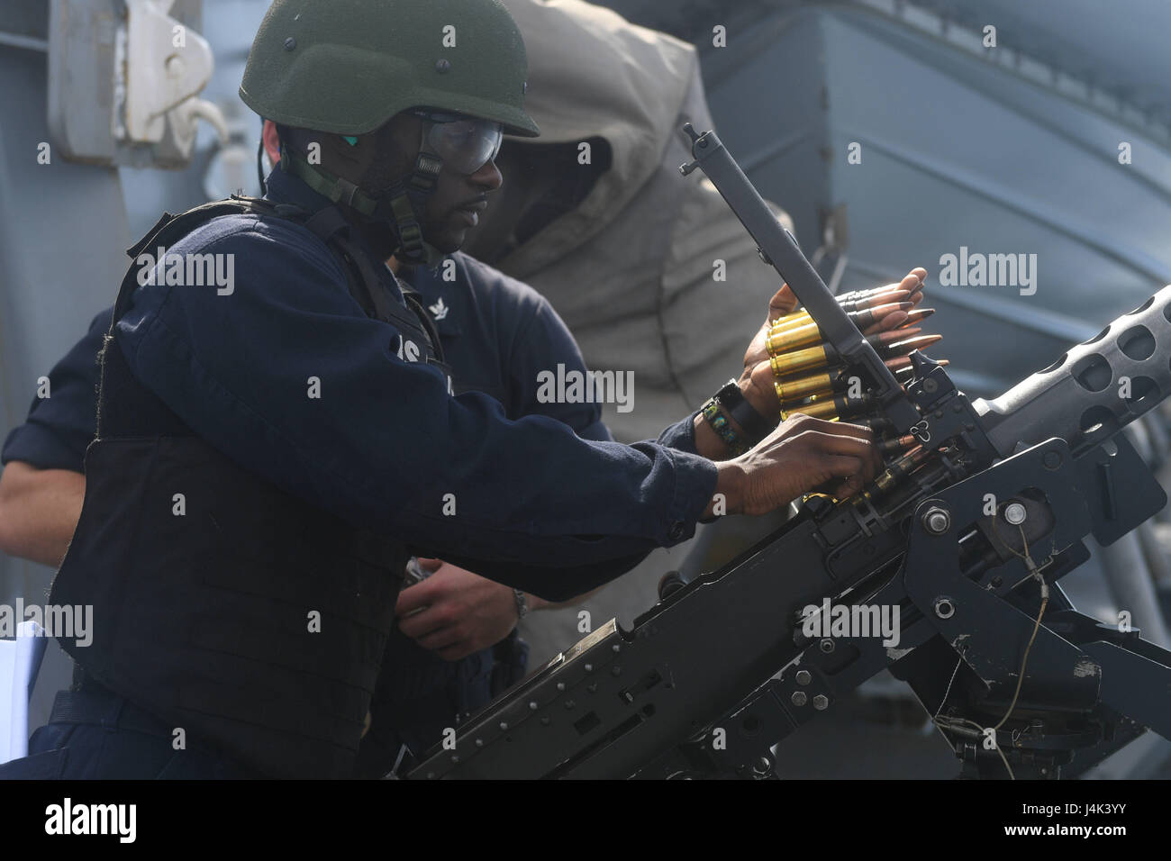 Logistics Specialist reloads a .50-caliber machine gun aboard the ...