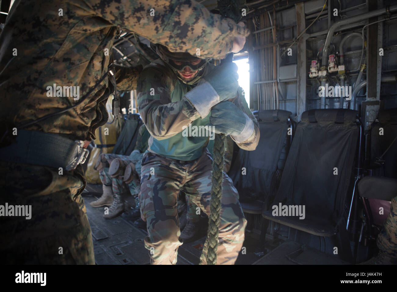A Royal Dutch Marine holds a rope in preparation for fast roping from a ...