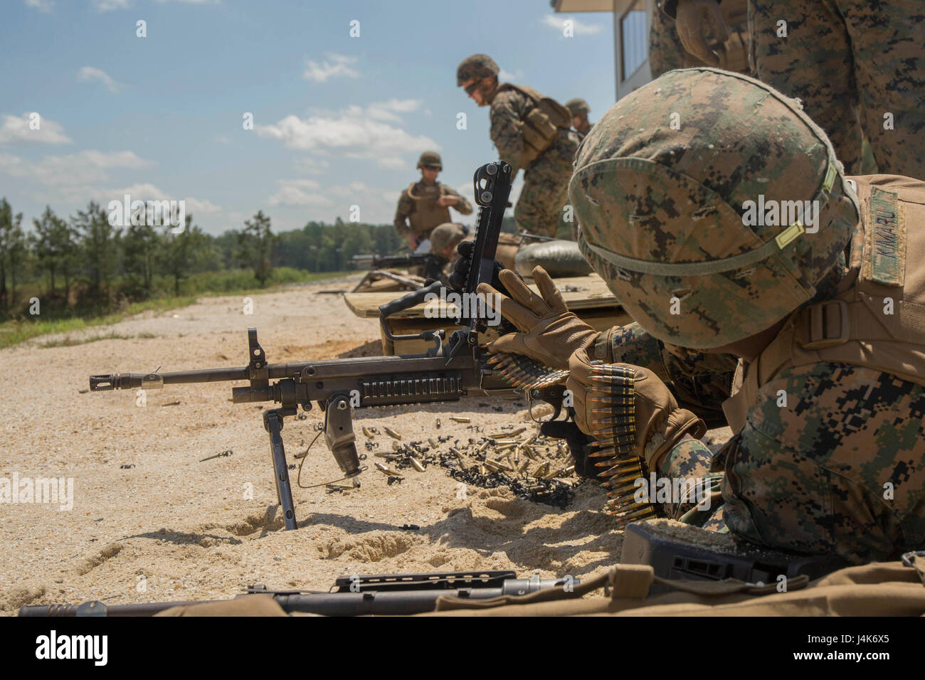 A Marine places rounds on the feed tray of an M249 light machine gun ...
