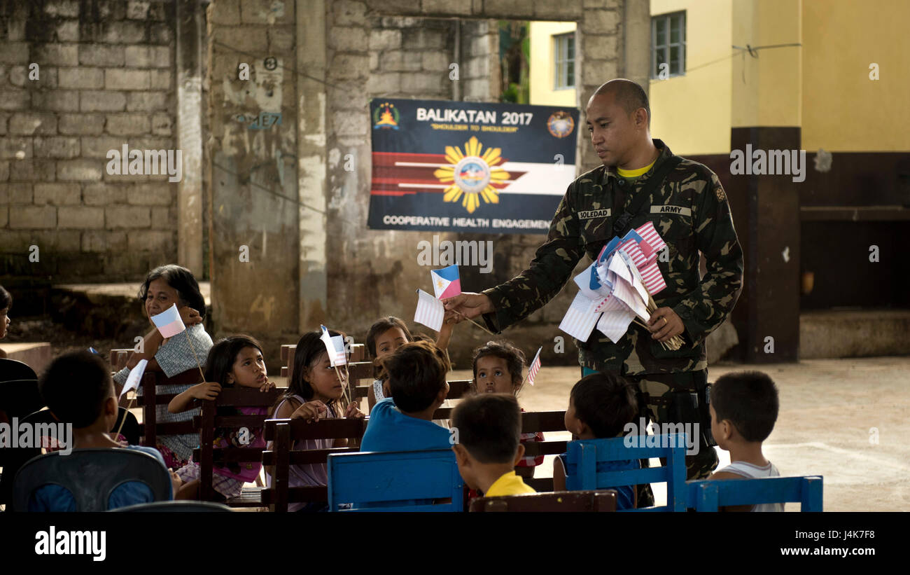 Philippine Army Pfc. Noel Soledad gives children Philippine and U.S ...
