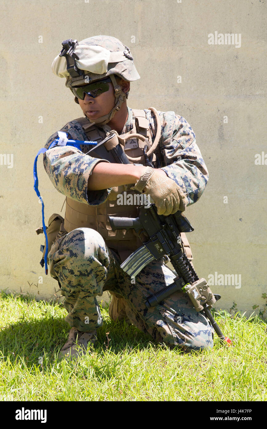 A Marine applies a tourniquet to his arm during a simulated Squad Overmatch mission at Camp ...