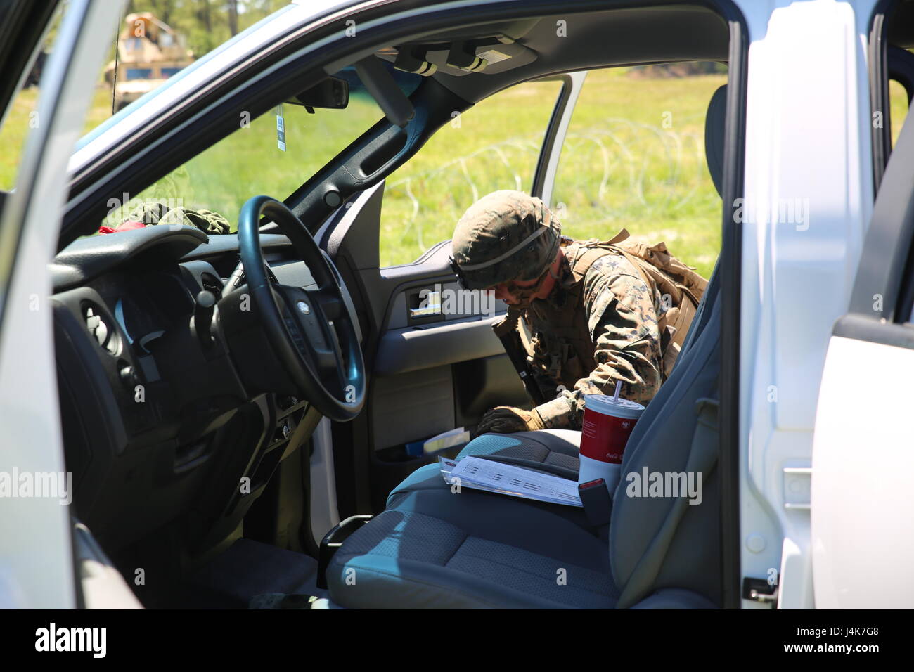 A Marine searches for contraband at a vehicle inspection check point ...