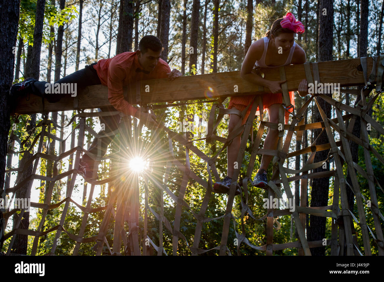 Participants maneuver themselves over a rope wall during the Moody Mud ...
