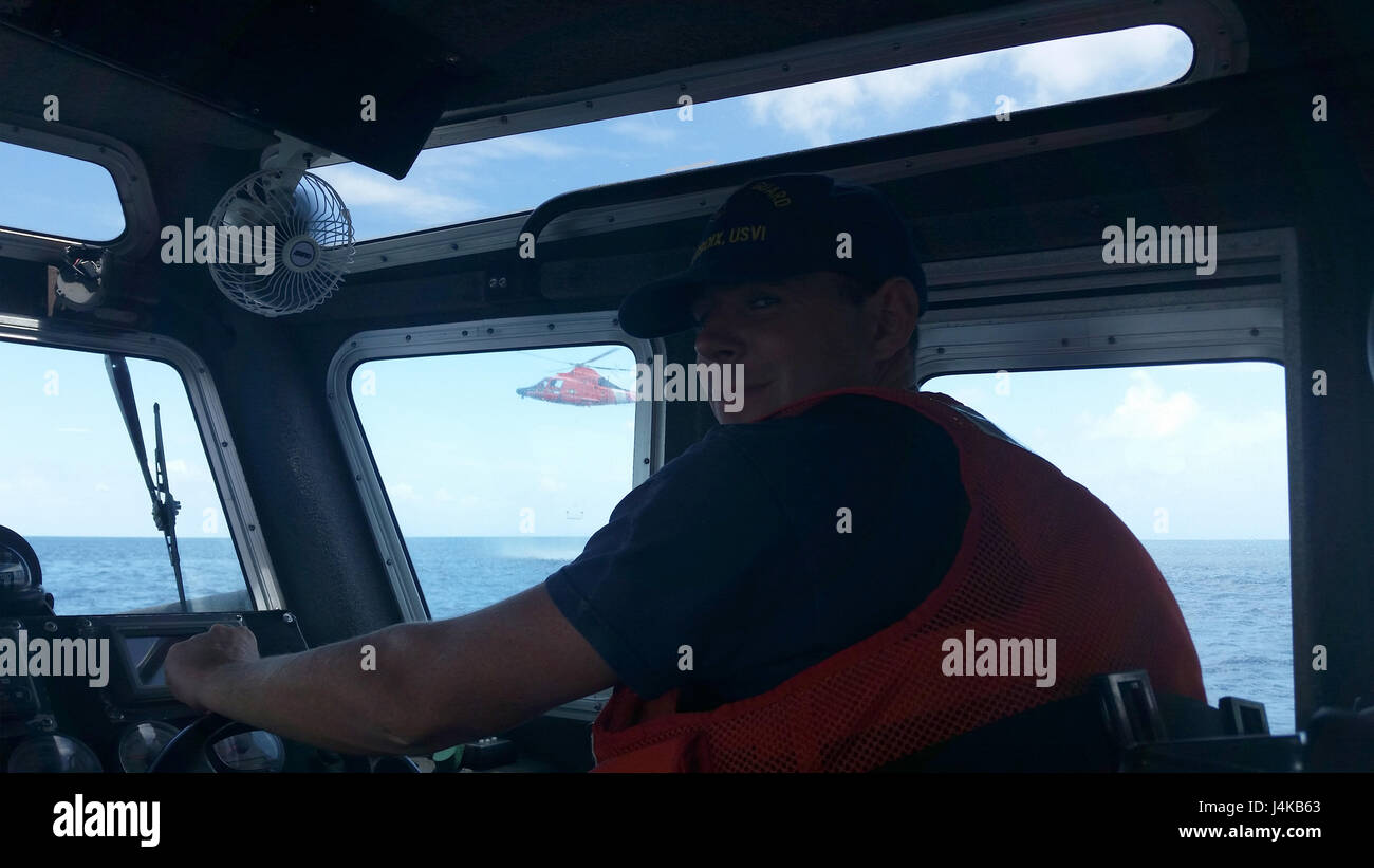 U.S. Coast Guard Boatswains mate 2nd Class Jack Trahan steers the boat ...