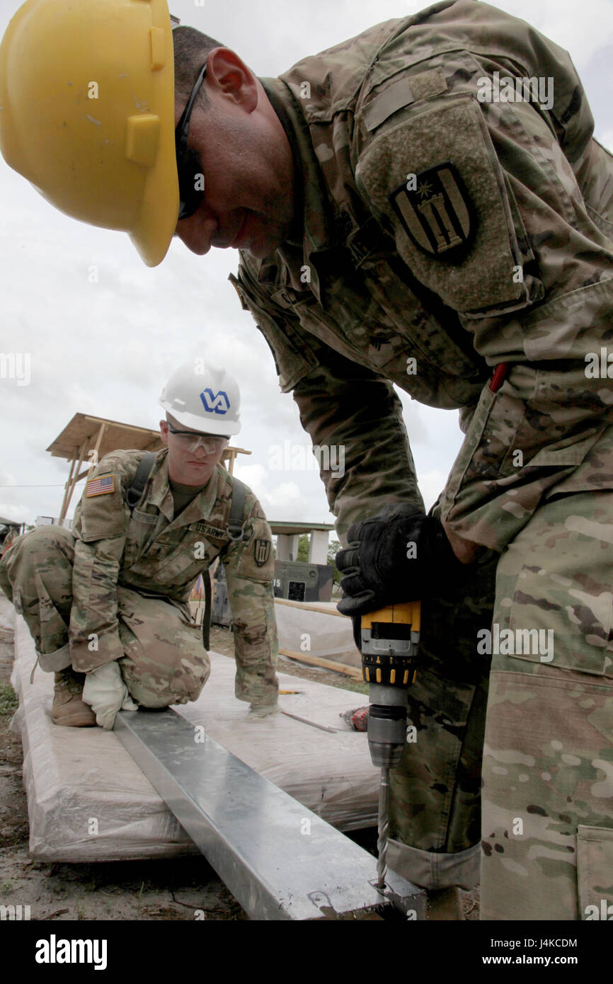 U.S. Army 1st Lt. Connor Mccourtney (left) assists Sgt. Anthony ...