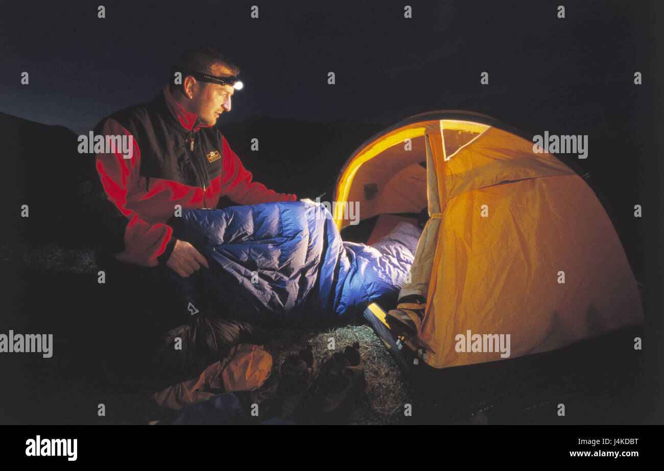 Camping, man, forehead lamp, tent, sleeping-bag, evening Germany, Upper ...