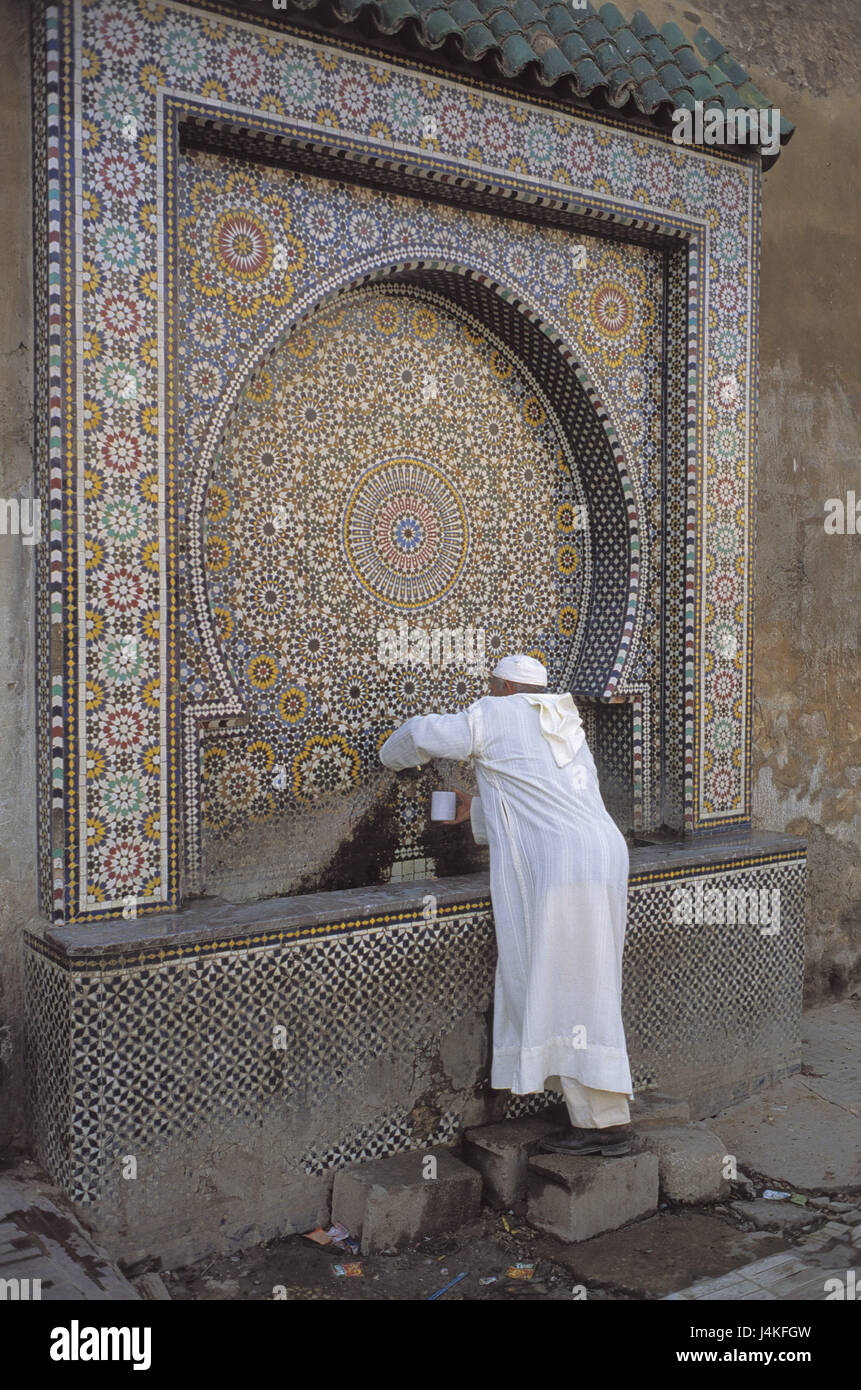 Morocco, Meknes, well, man, drinking mug, back view no model release ...