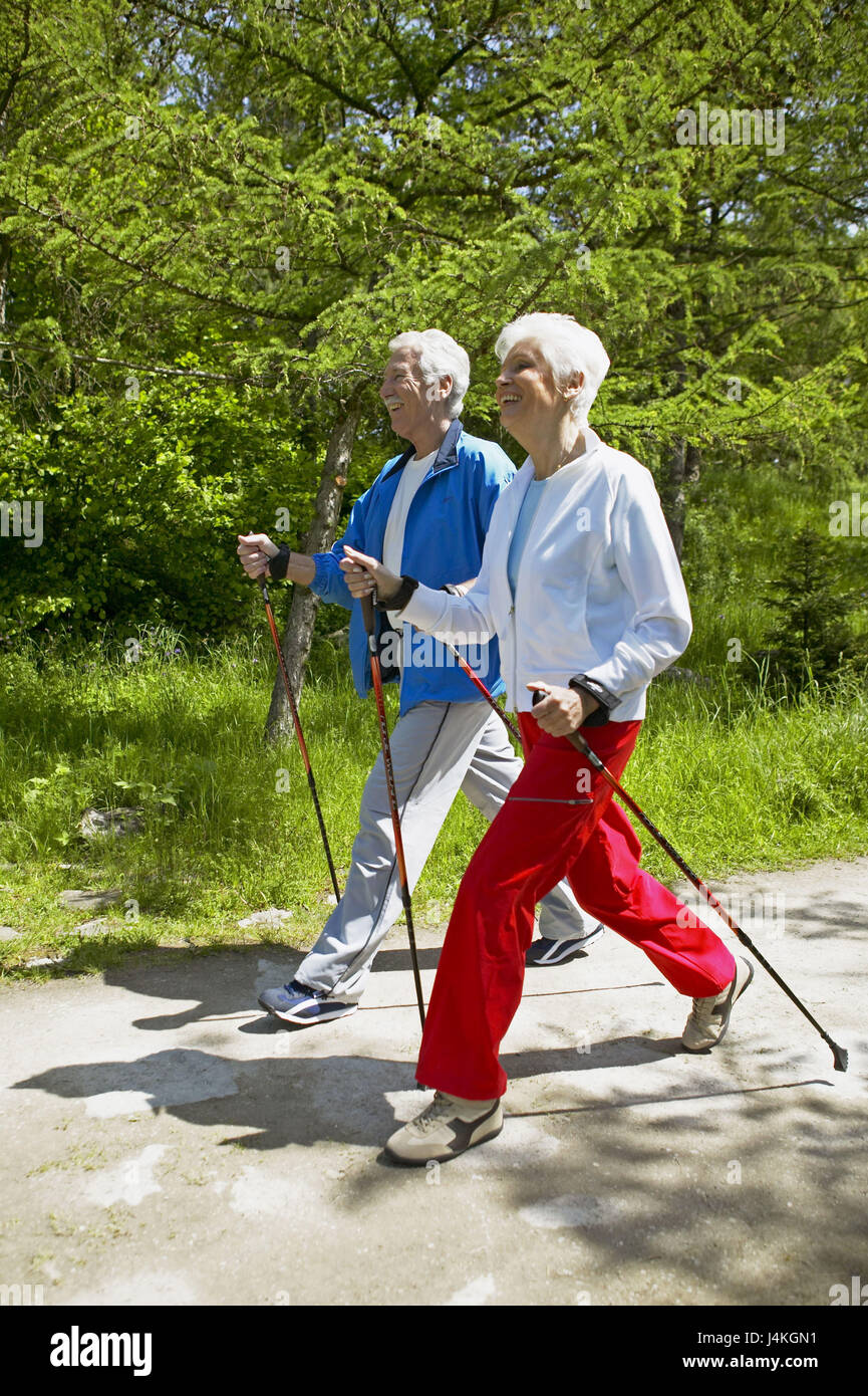 Forest way, senior citizen's couple, Nordic Walking, at the side ...
