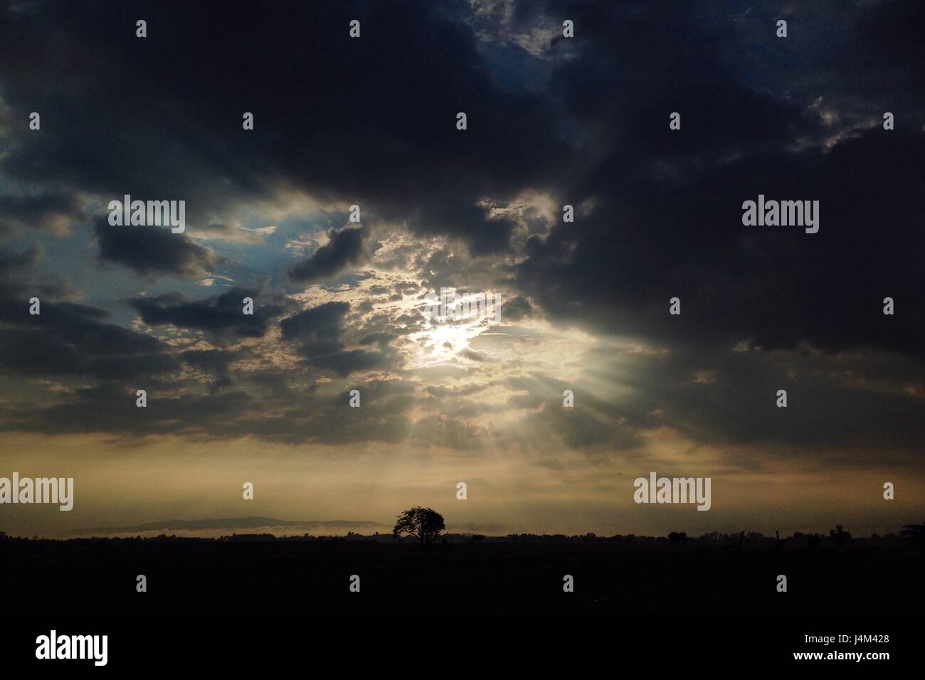 Overcast day sun beam through the clouds Stock Photo - Alamy