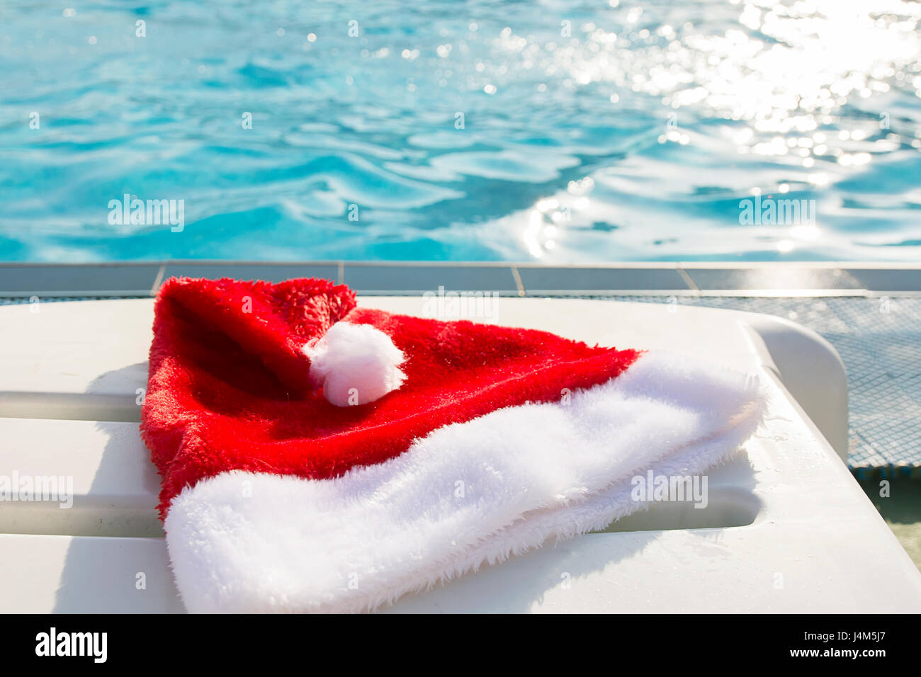 Christmas hat by the swimming-pool on a sunny day at a warmer ...