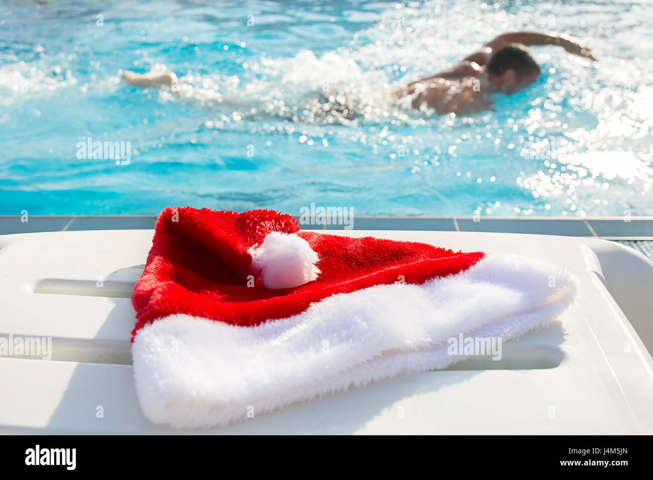 Christmas hat by the swimming-pool on a sunny day at a warmer ...