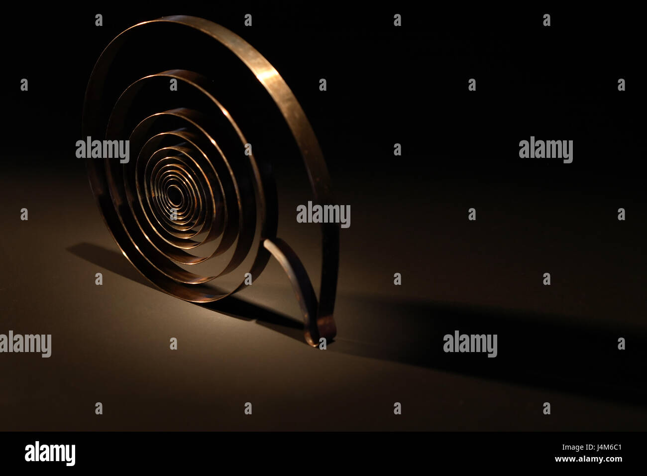 Rusty metal spring on dark background under beam of light Stock Photo ...