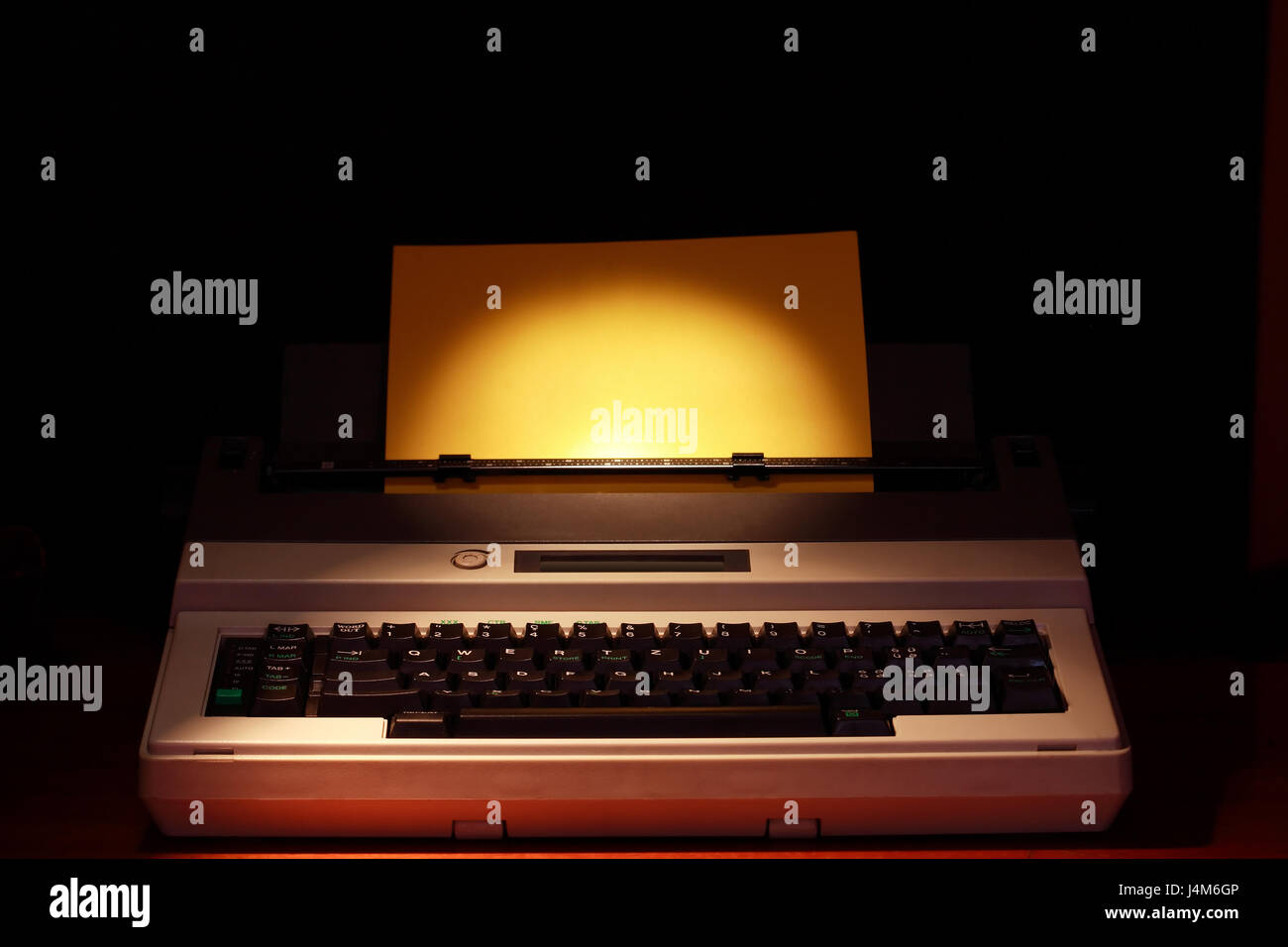 Electrical typewriter closeup with blank yellow paper sheet on dark ...