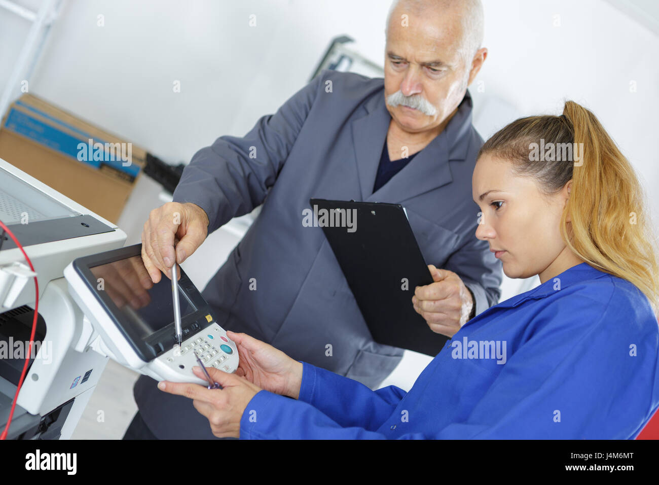 Apprentice technician following instructions from teacher Stock Photo ...