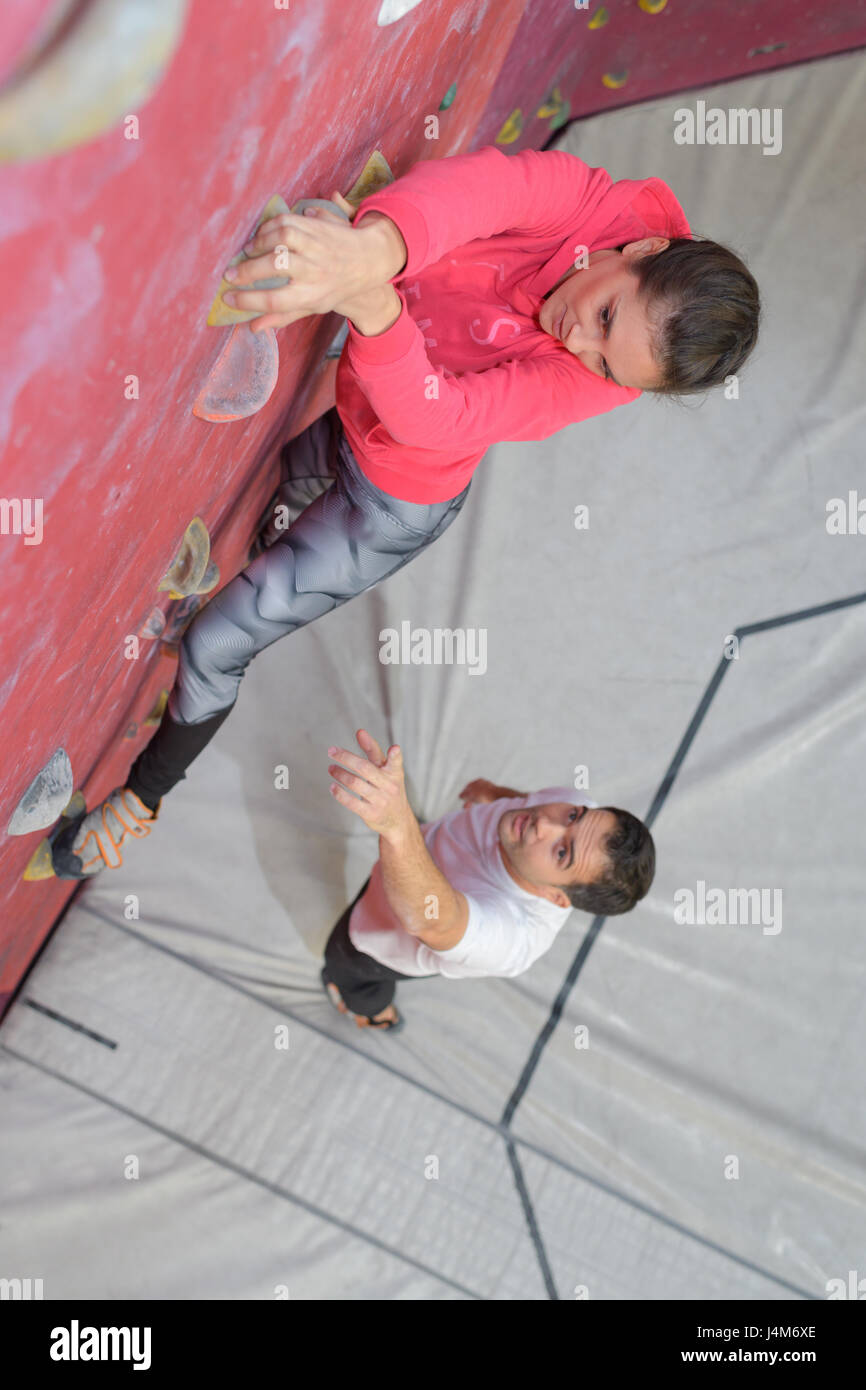 Lady climbing indoor wall Stock Photo - Alamy