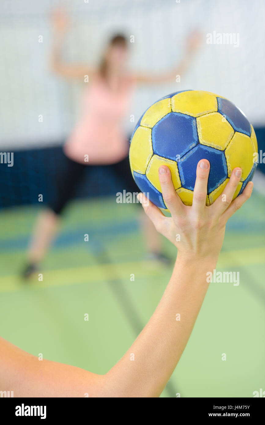 sportsman holding a ball against handball goal Stock Photo - Alamy