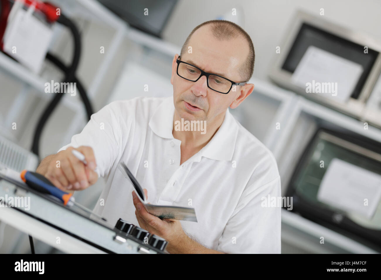 Technician reading instruction manual Stock Photo - Alamy