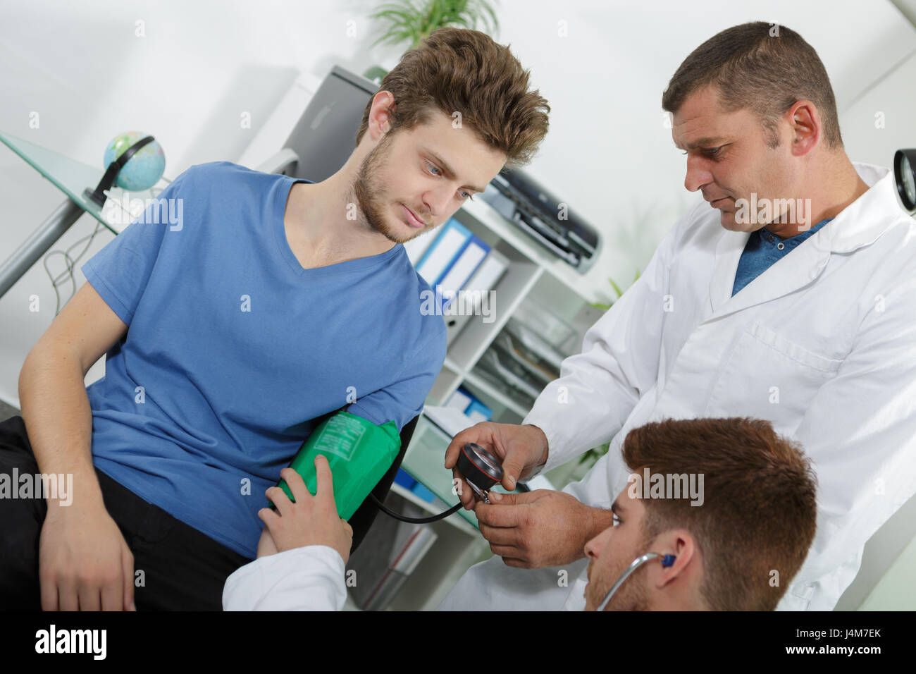 Young man having blood pressure tested Stock Photo - Alamy