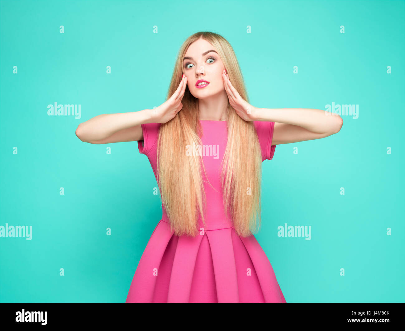 The beautiful young woman in pink mini dress posing at studio Stock ...