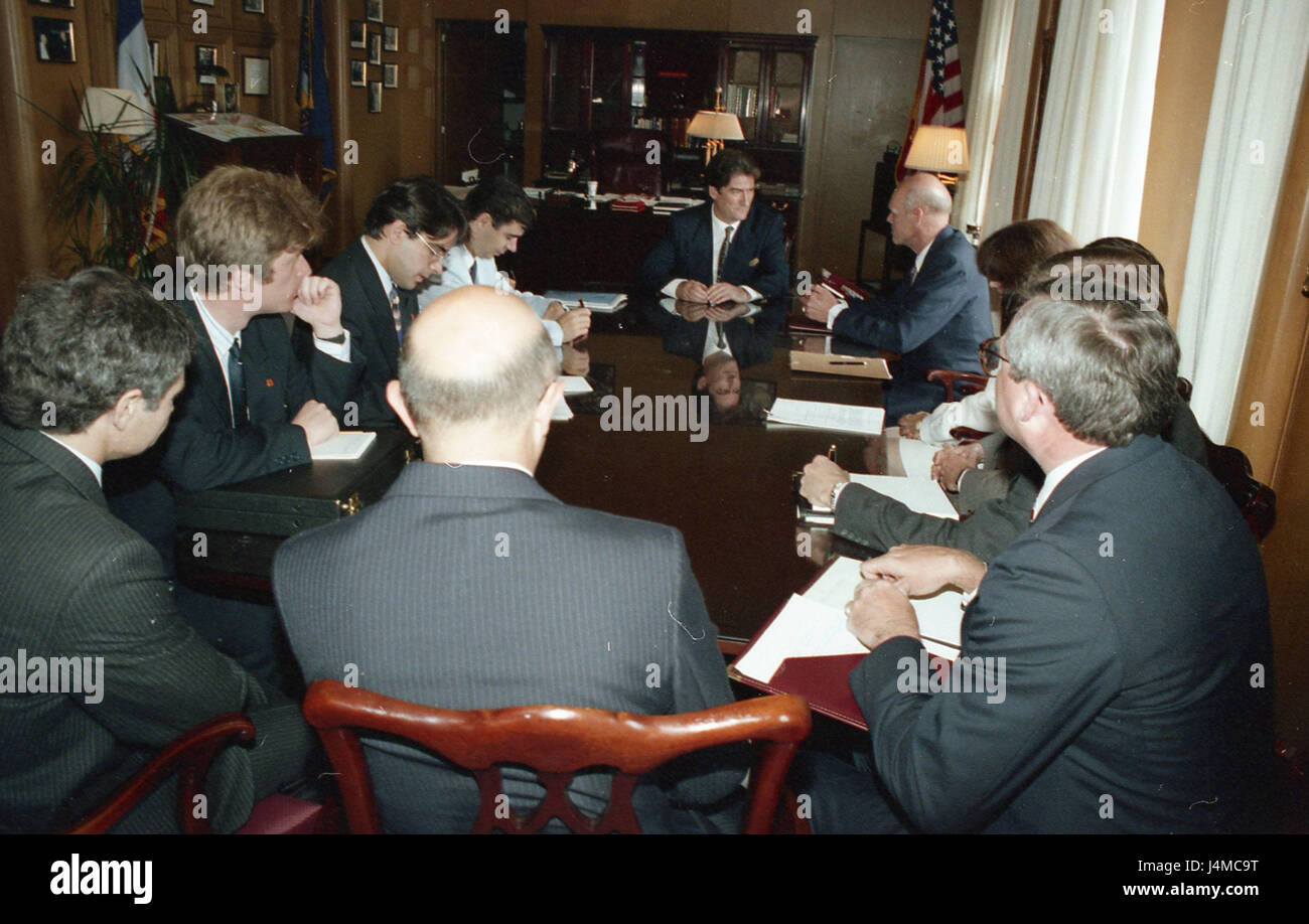 men and woman sitting at conference table Stock Photo - Alamy