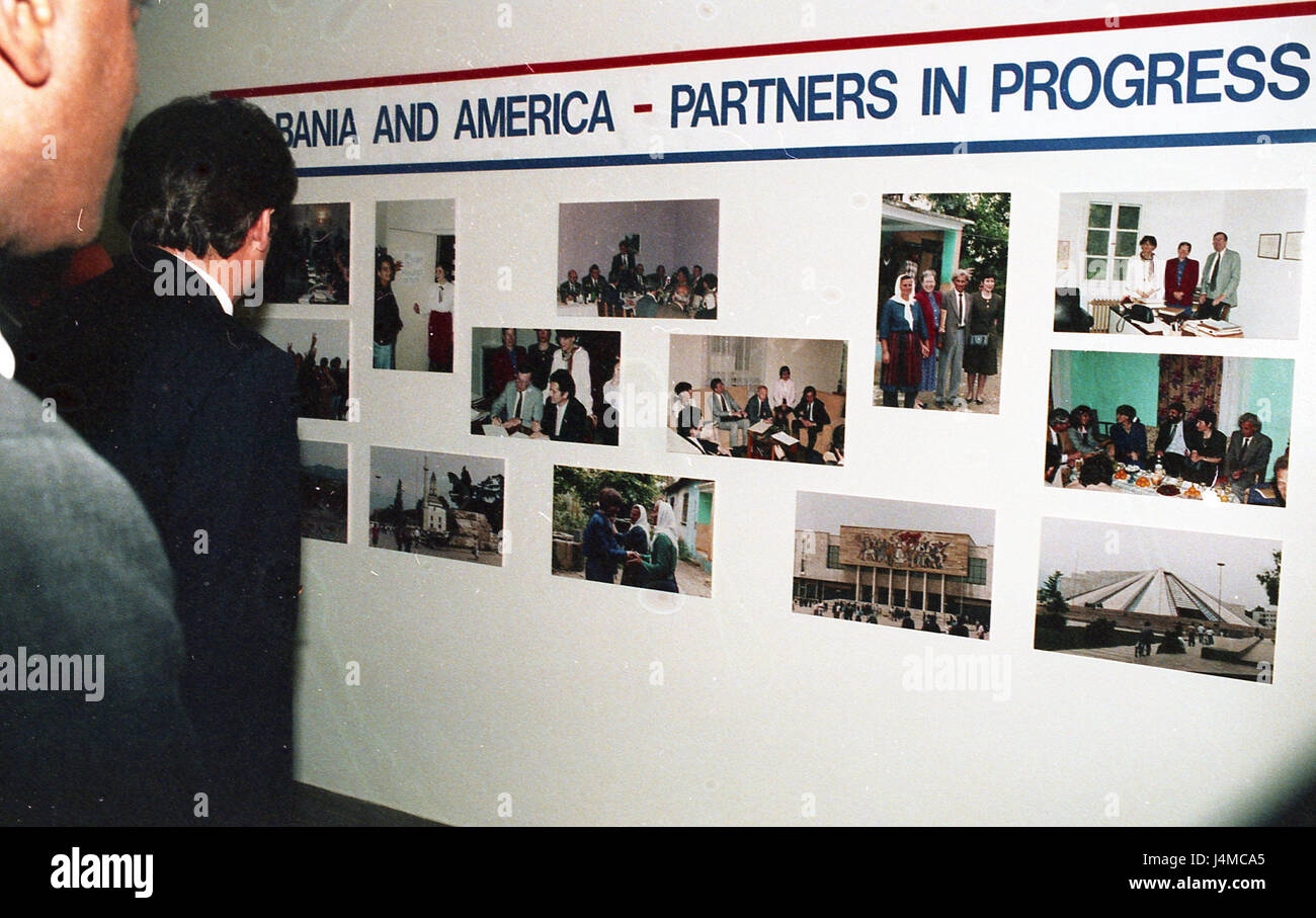 MEN AND WOMAN LOOKING AT POSTER Stock Photo - Alamy