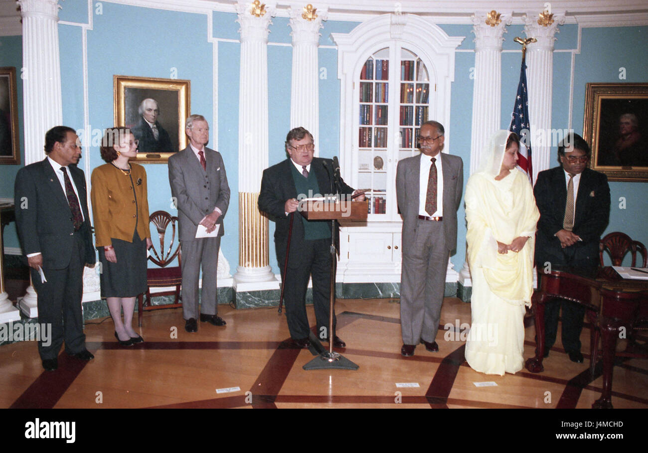 THERE IS A MAN AT THE PODIUM READING TO A GROUP OF PEOPLE Stock Photo ...
