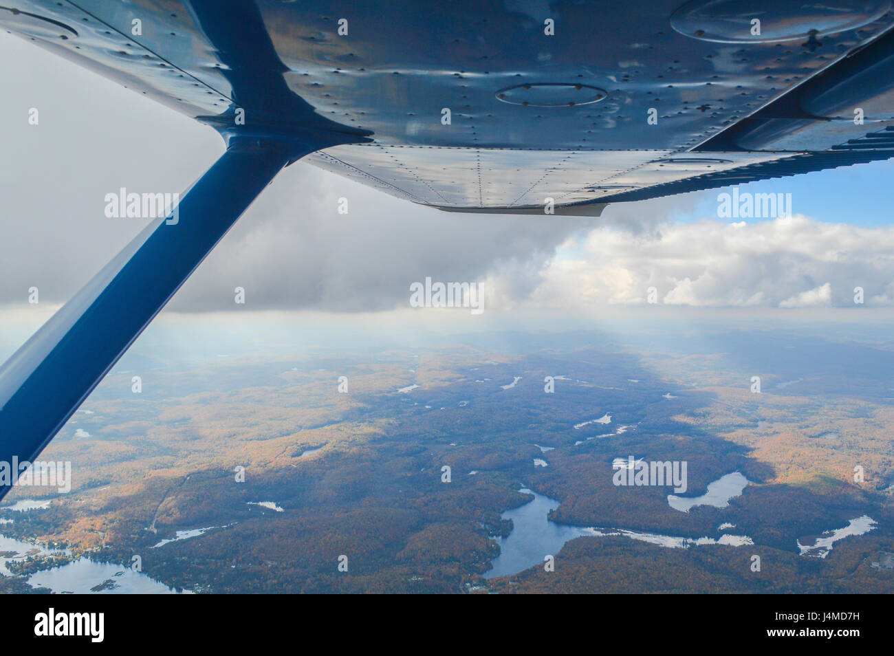 Flying a small aircraft during fall season at the base of the clouds at ...
