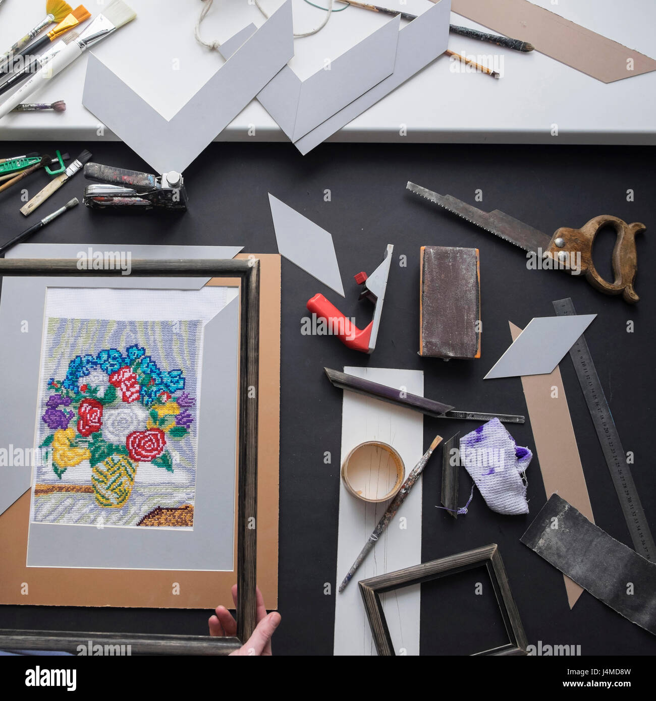 Hand holding picture frame near tools on table Stock Photo - Alamy