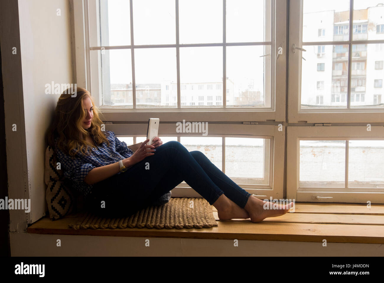 Woman sitting window sill hi-res stock photography and images - Alamy