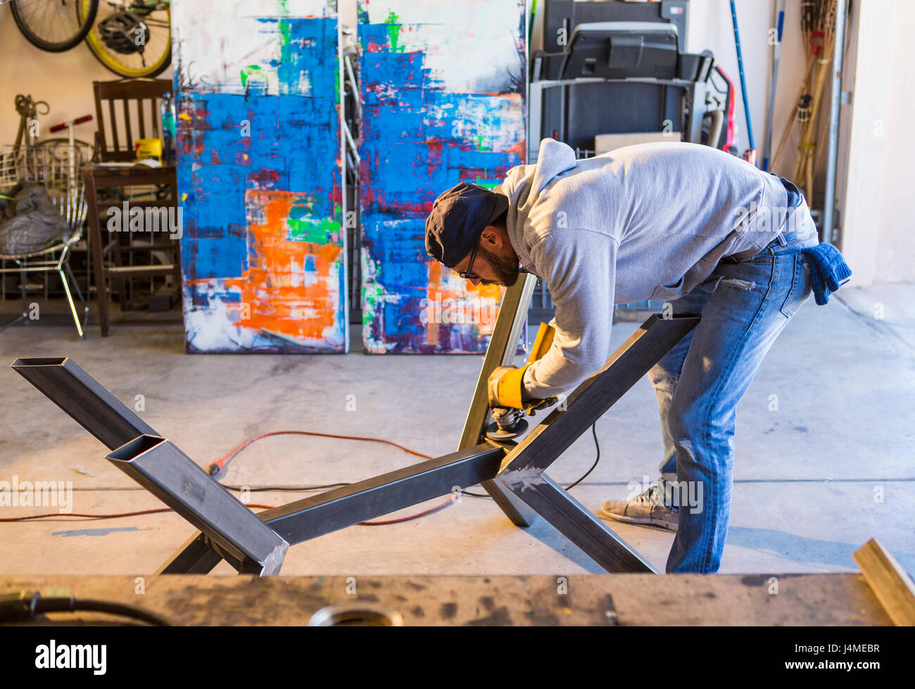 Caucasian man grinding metal sculpture Stock Photo - Alamy