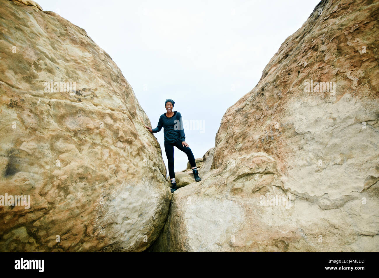 Smiling young woman standing rock hi-res stock photography and images ...