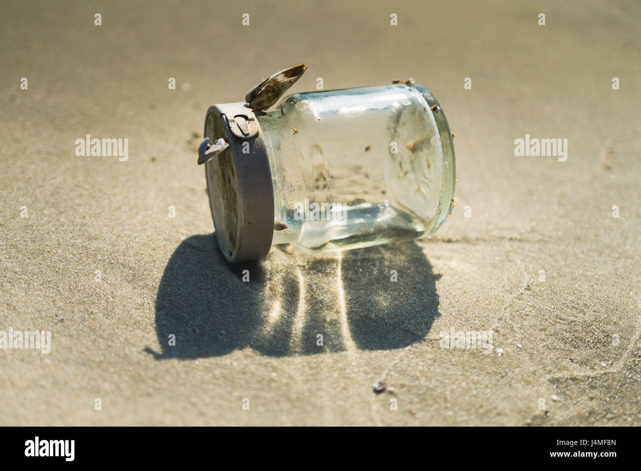 Empty glass bottle on sandy beach Stock Photo - Alamy