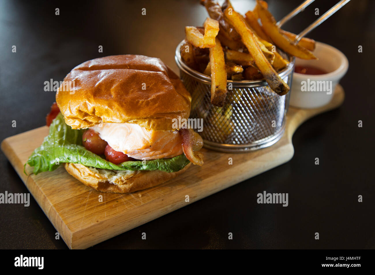 A salmon burger served with fries in Vancouver, Canada. The burger ...