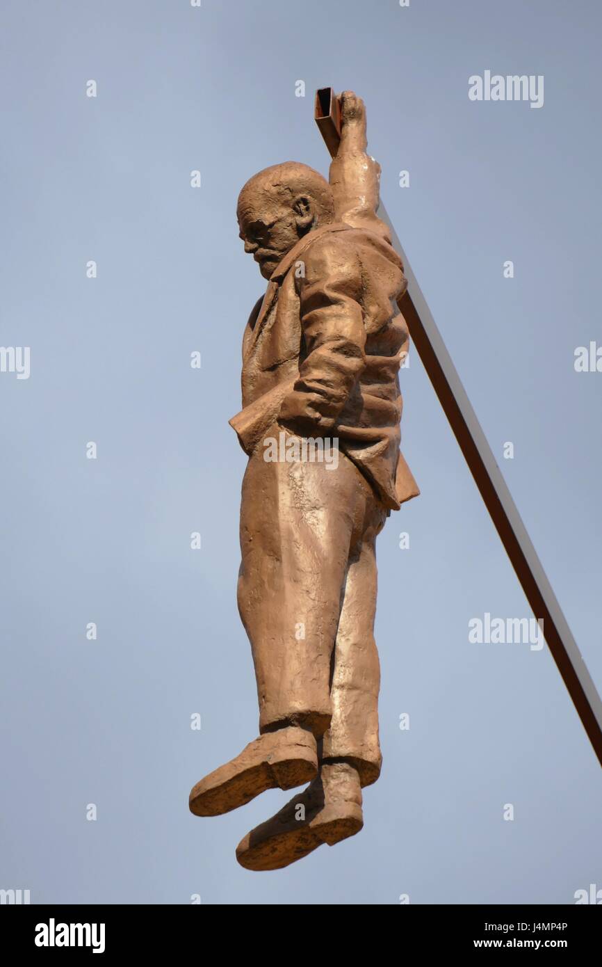 Hanging man art work suspended above residential street in the city of ...