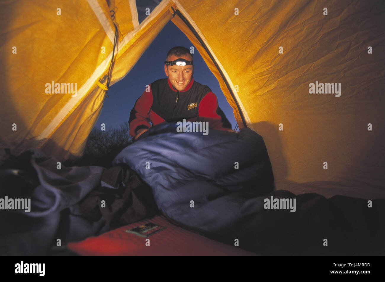 Camping, man, forehead lamp, tent, sleeping-bag, evening Germany, Upper ...