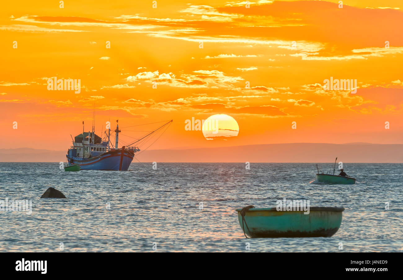 Sunset and boat on the sea as the sun slowly down the horizon circle ...