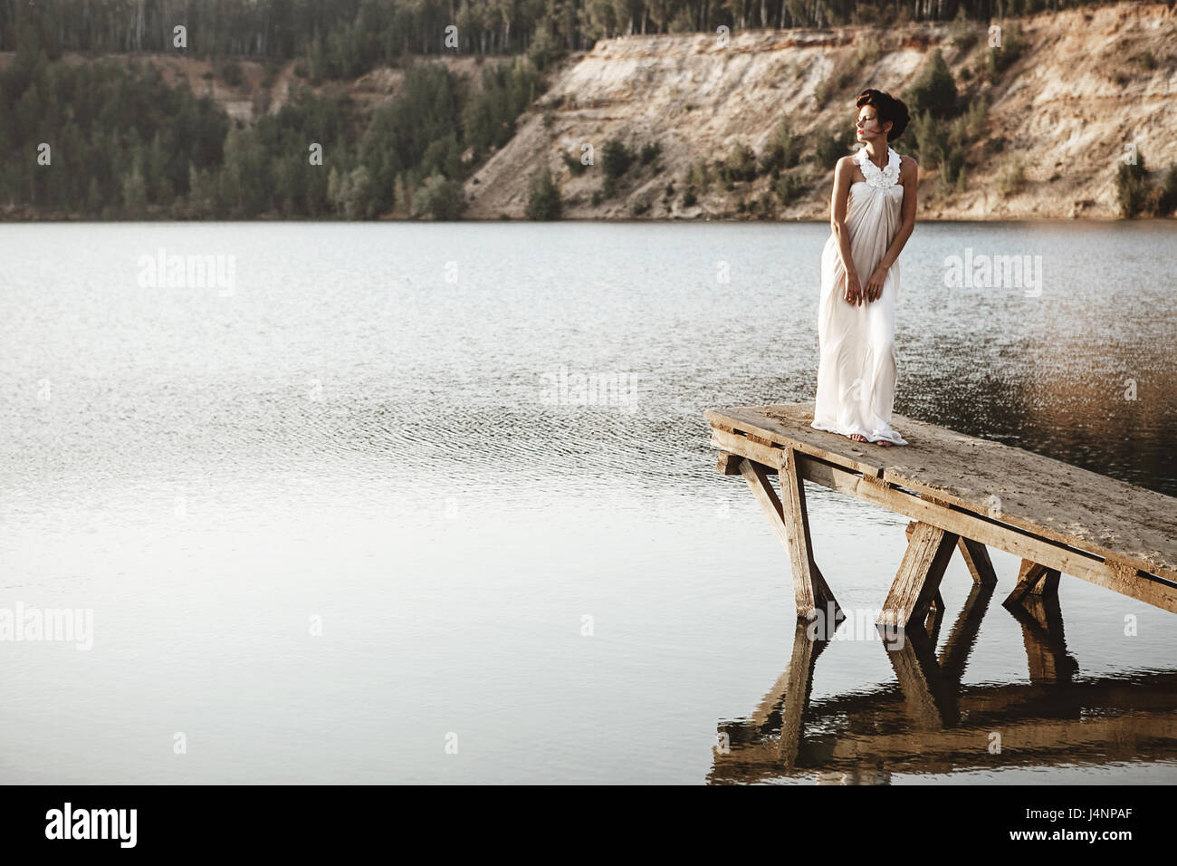 girl standing on a pier on a lake Stock Photo - Alamy