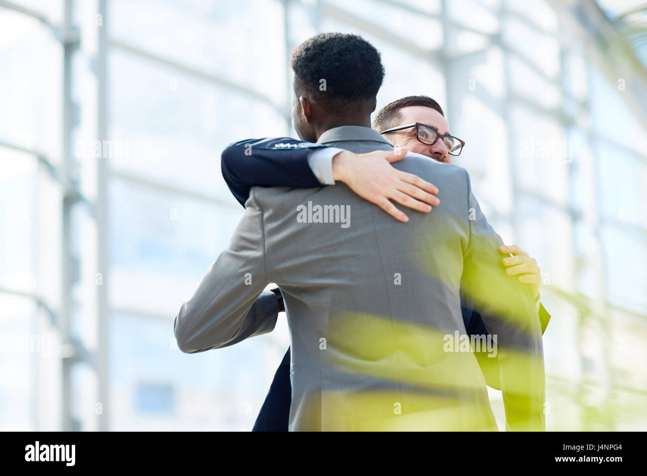 Portrait of two business partners hugging and smiling with happiness ...