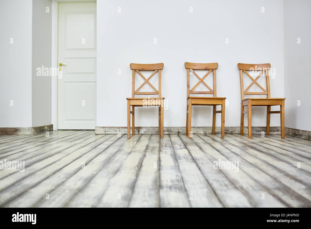 Row of wooden chairs along wall of room Stock Photo - Alamy