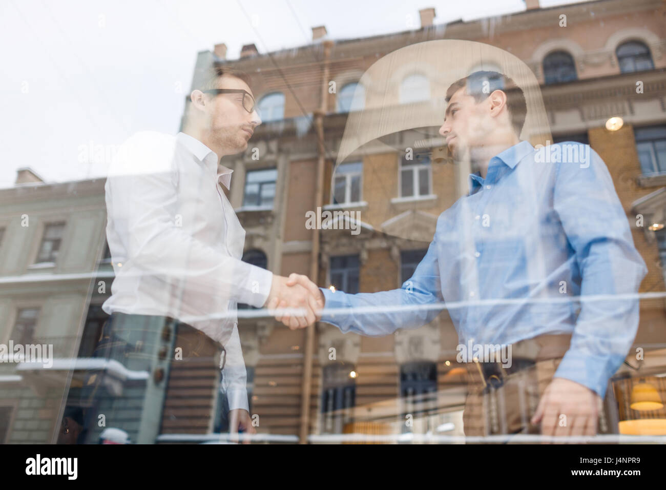 Side view portrait of two businessmen shaking hands after successful ...