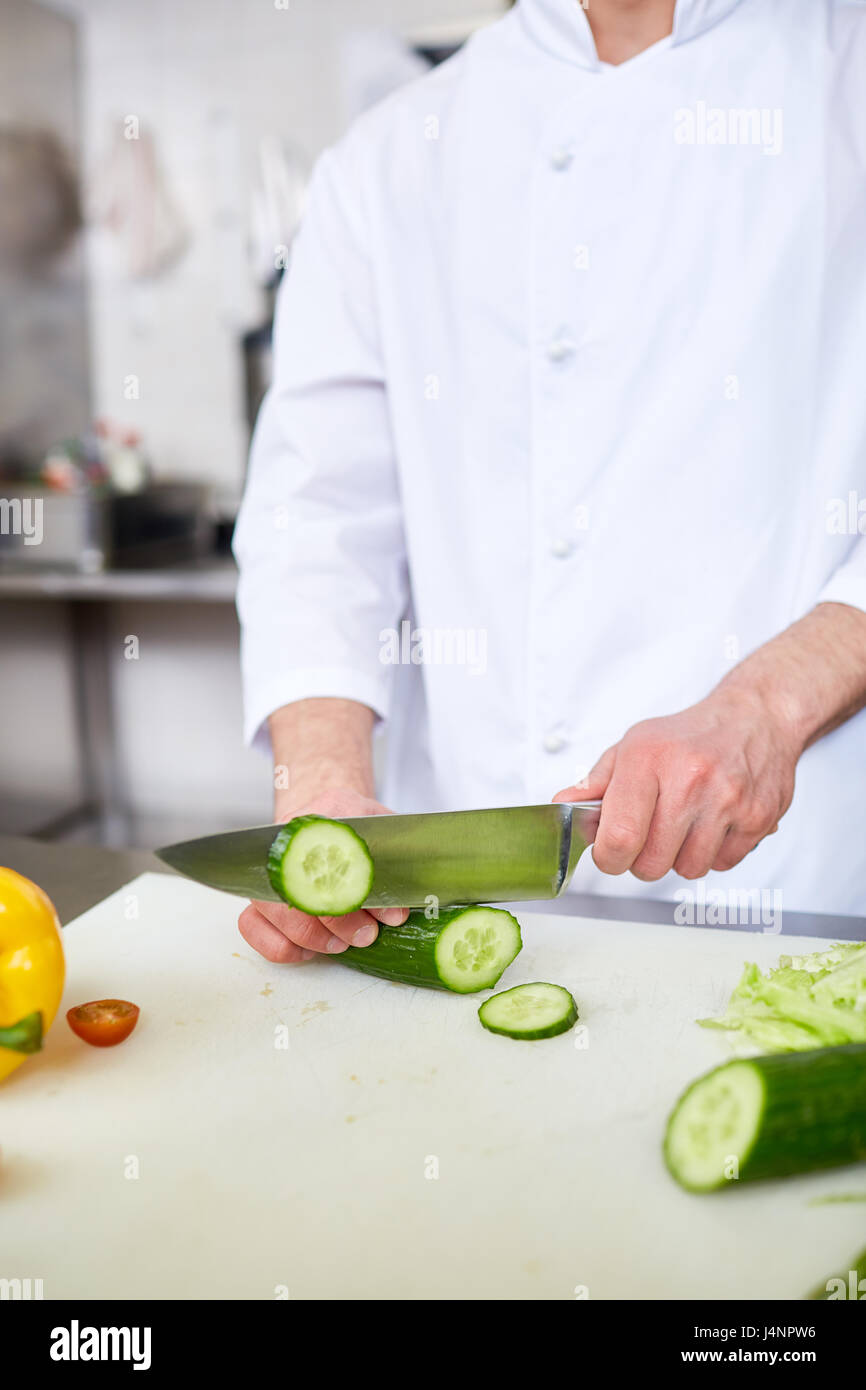 Chef slicing fresh cucumber for salad Stock Photo - Alamy