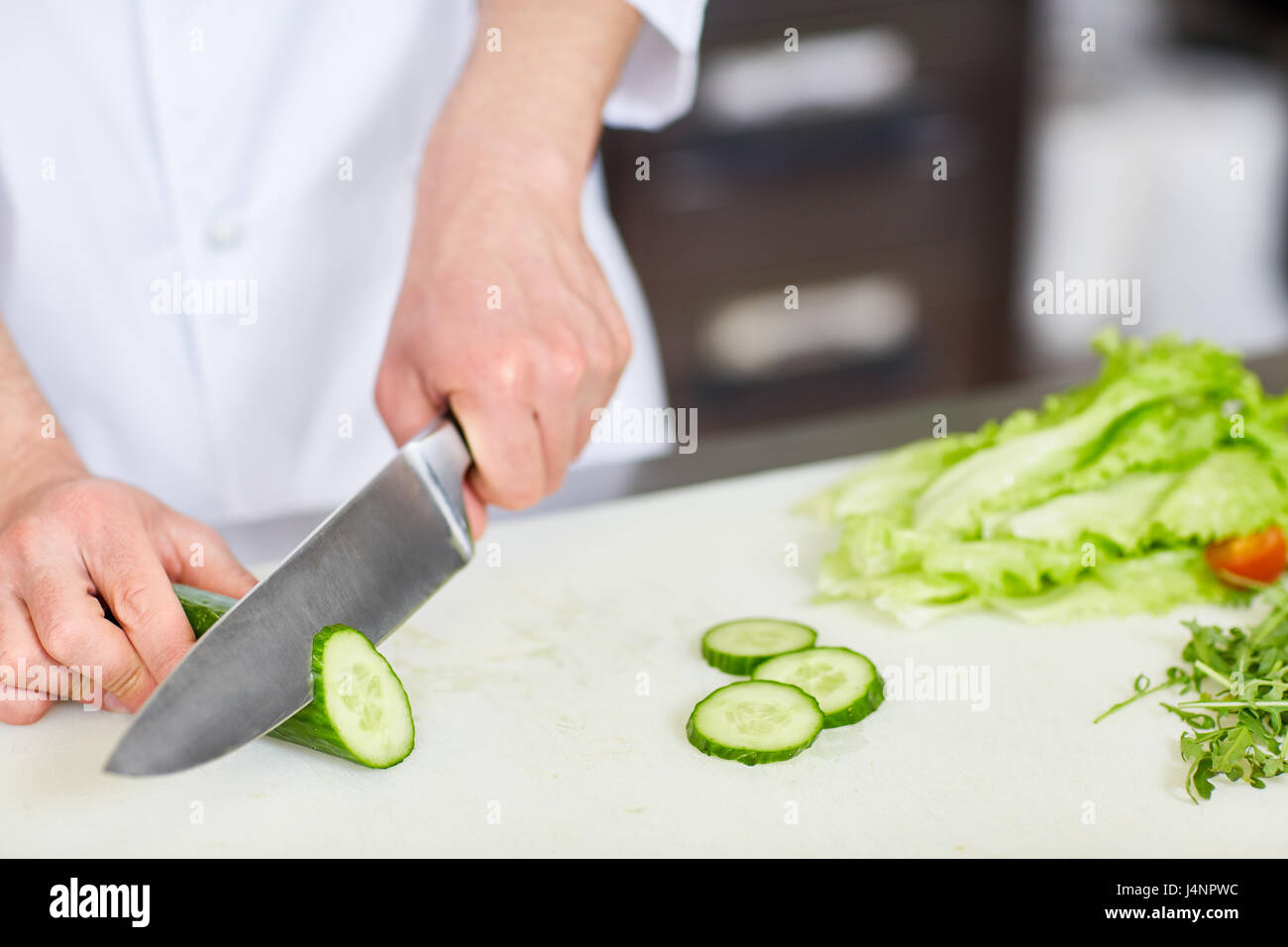 Human hand with sharp knife cutting fresh cucumber Stock Photo - Alamy
