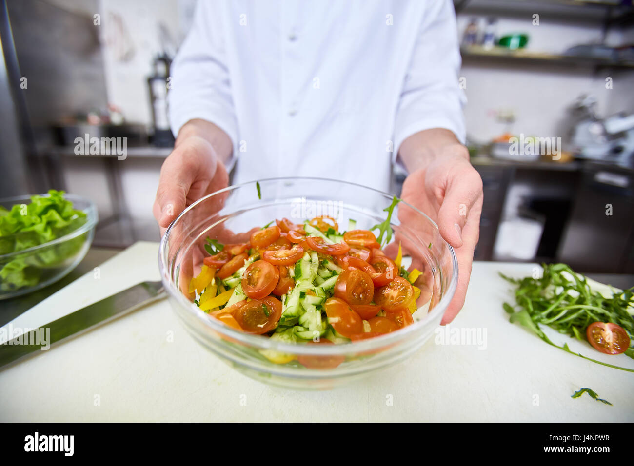Chef showing cooked salad in bowl Stock Photo - Alamy