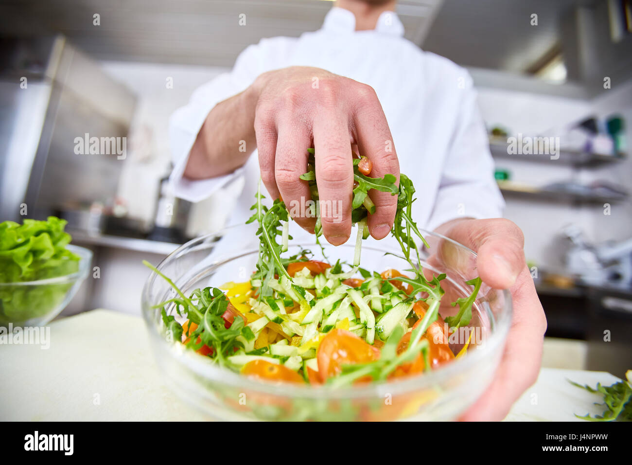 Chef mixing salad ingredients in bowl Stock Photo - Alamy