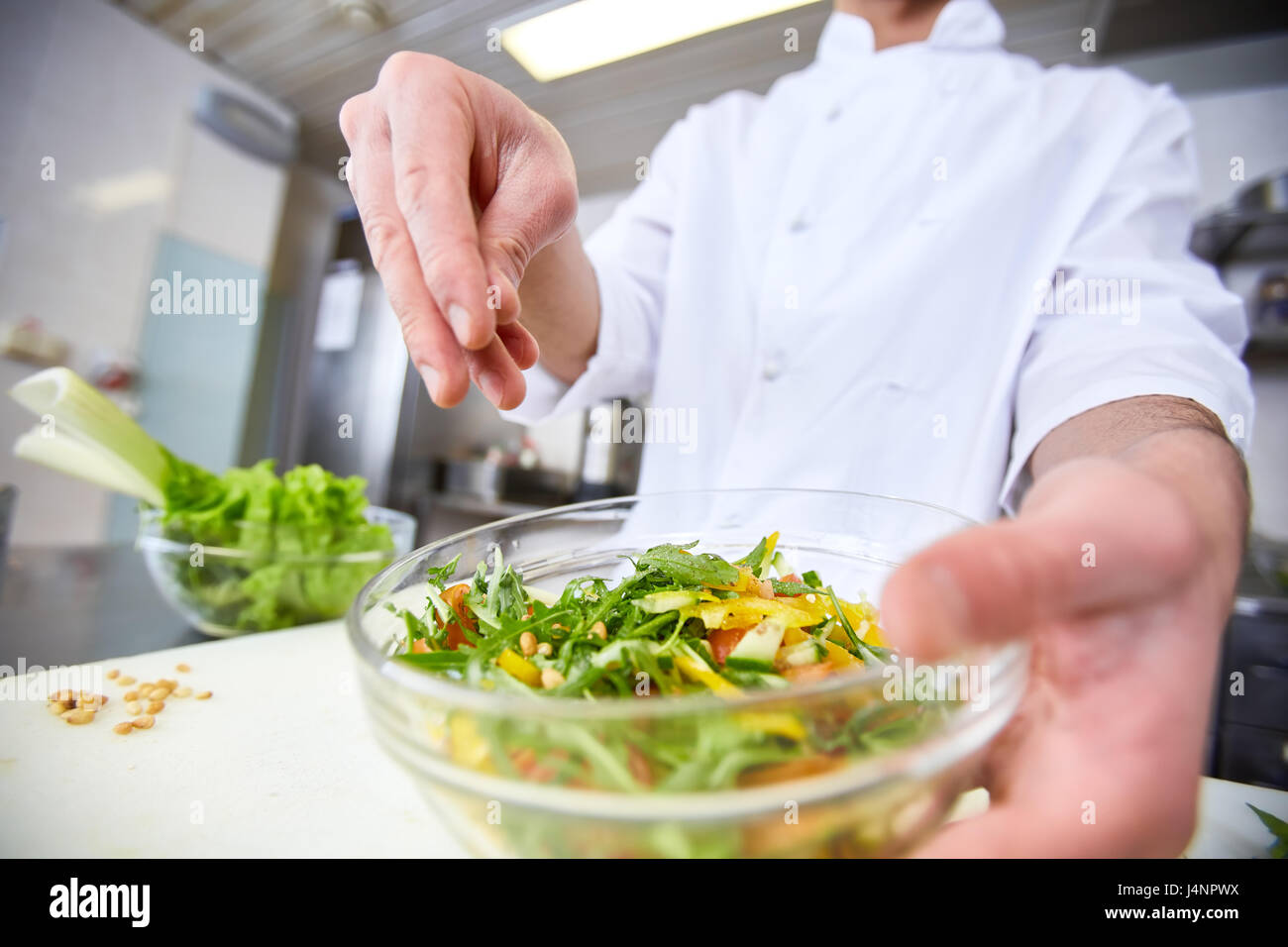 Chef seasoning salad by ground nutmeg Stock Photo - Alamy