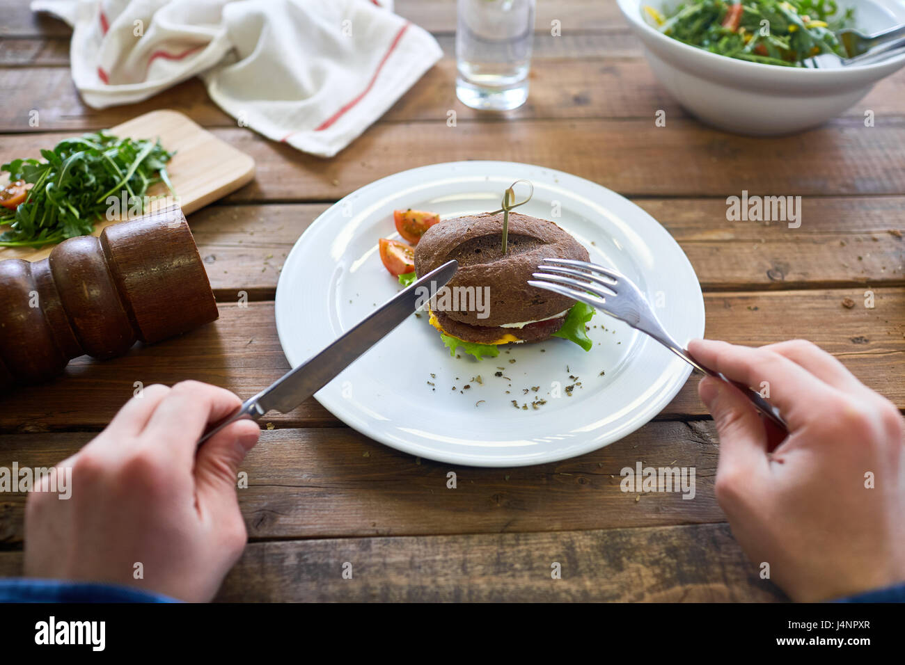 Human hands with fork and knife cutting sandwich on plate Stock Photo ...