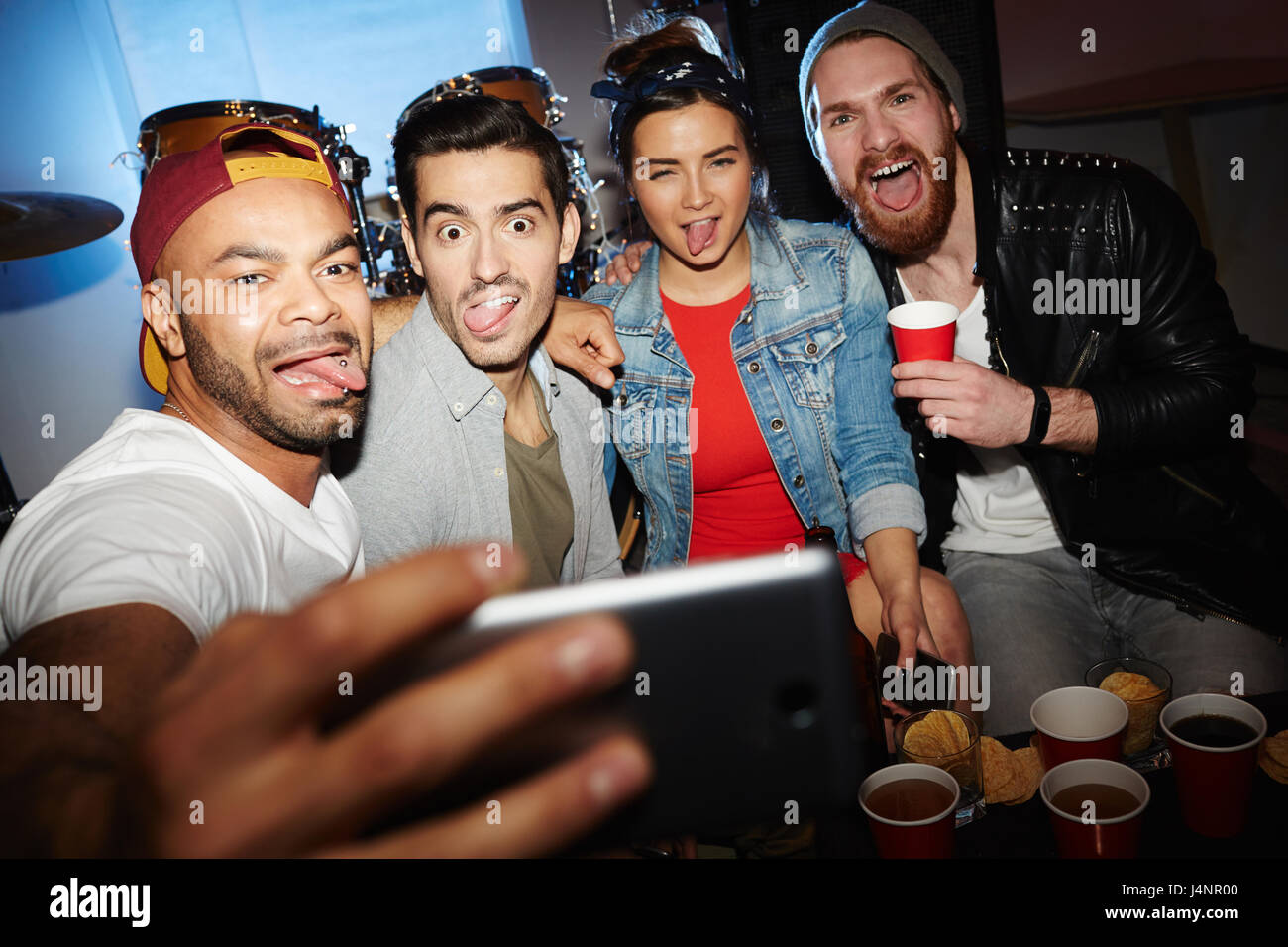 Group of modern young people chilling at night club party, posing for ...
