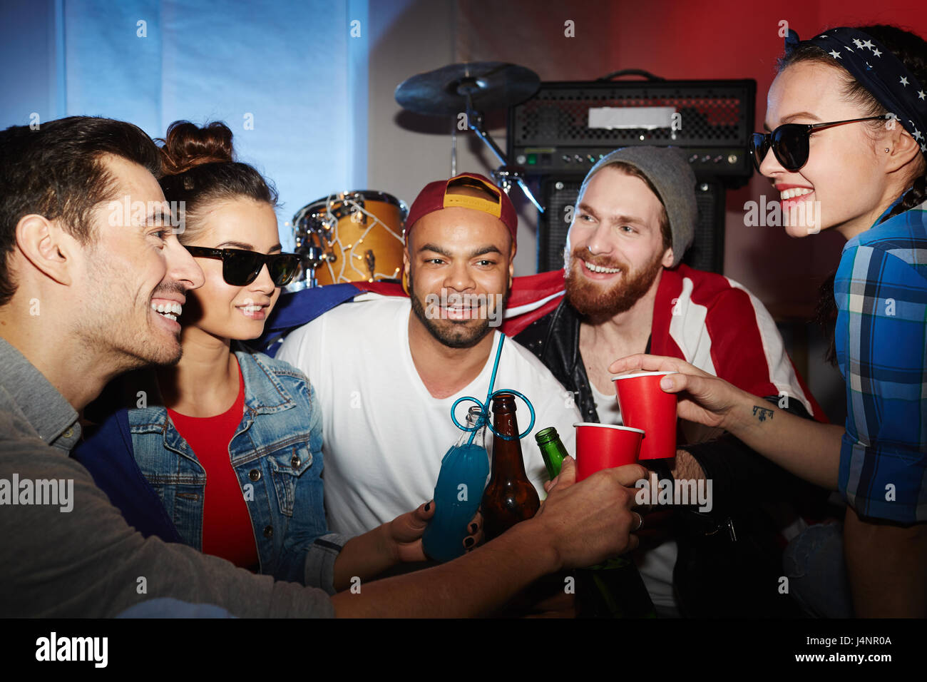 Multi -ethnic group of smiling young people hanging out in nightclub ...