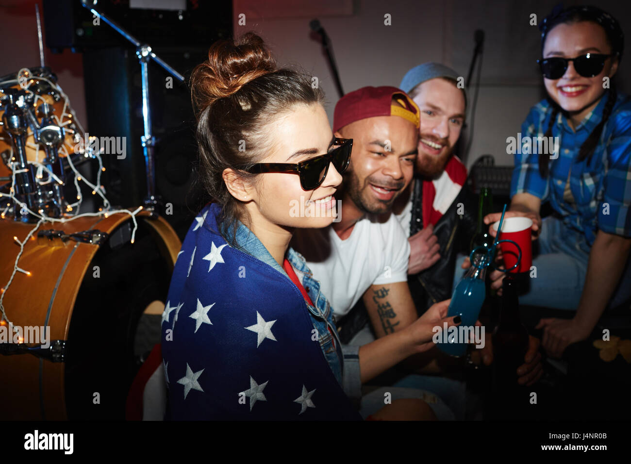 Multi-ethnic group of smiling young people hanging out in nightclub ...